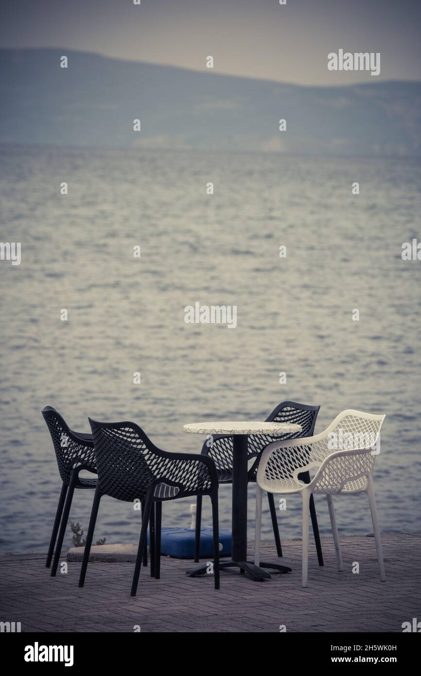Color image of empty chairs and tables at an open air terrace, near a ...