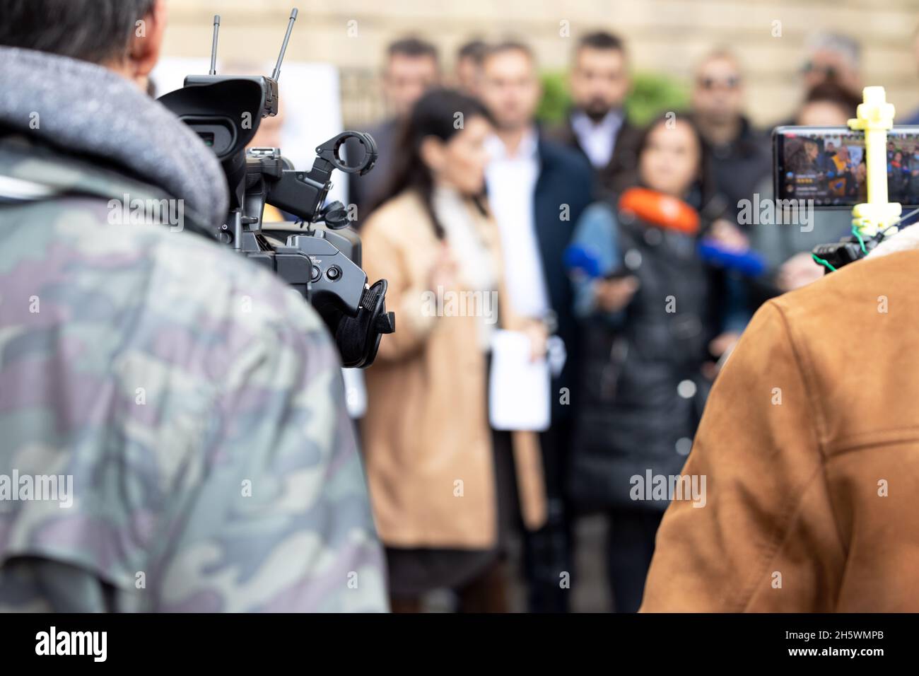 Filming media event or press conference with video camera and ...