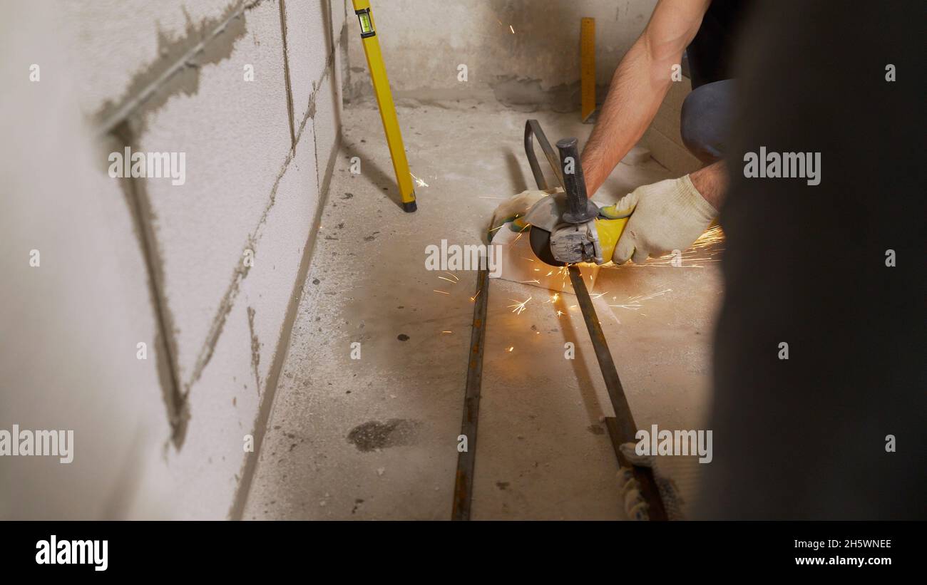 A worker cuts reinforcement at a construction site. Close-up - a ...