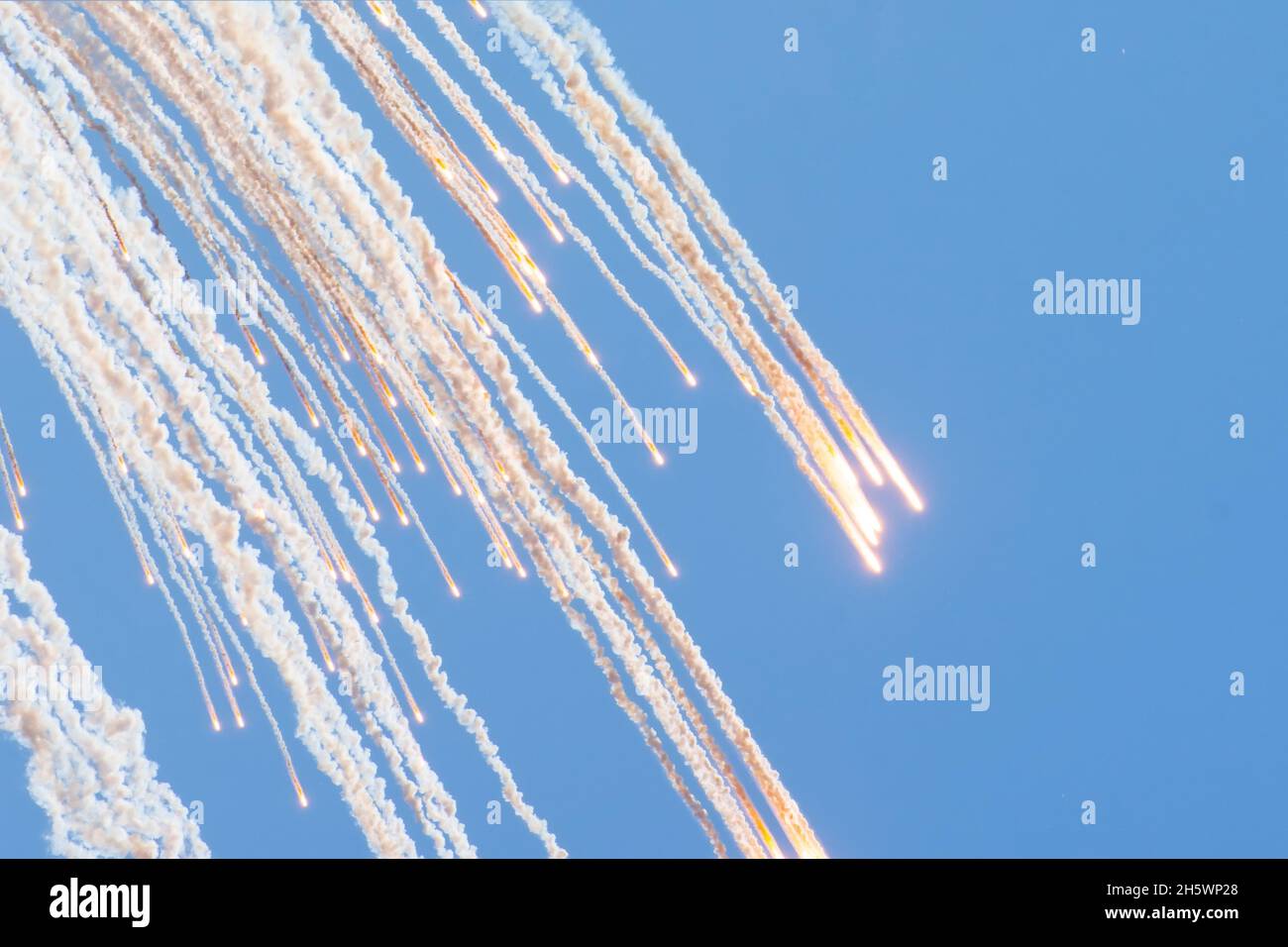 Many falling burning lights from the explosion in the blue sky leave a ...