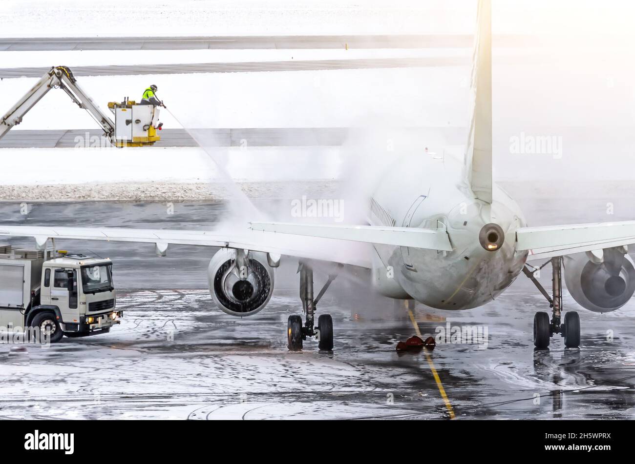 Ground crew provides de-icing. They are spraying the aircraft, which ...