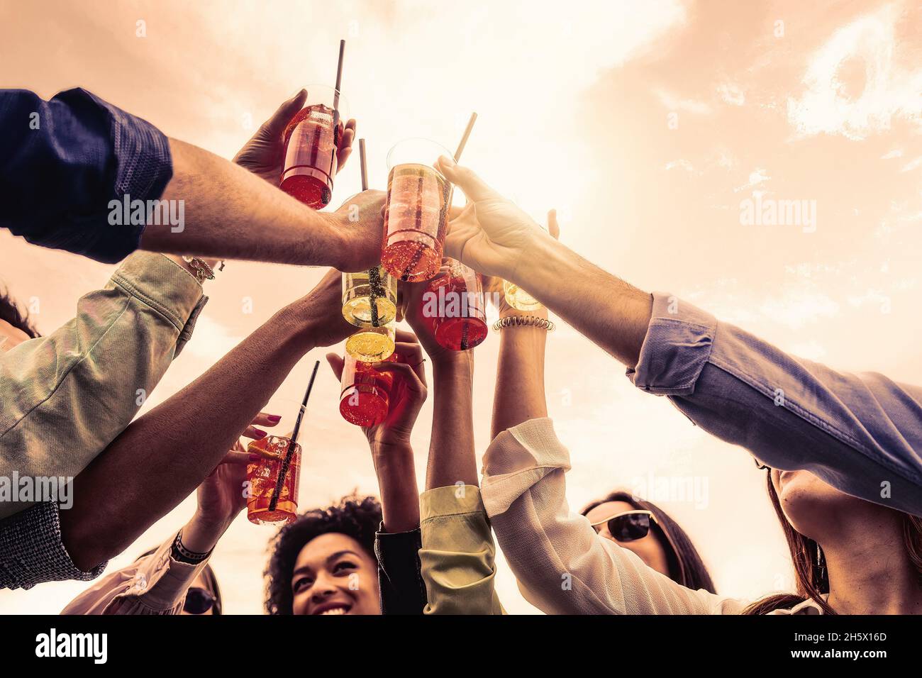 Happy people toasting cocktails in plastic glasses outdoors - gathering ...