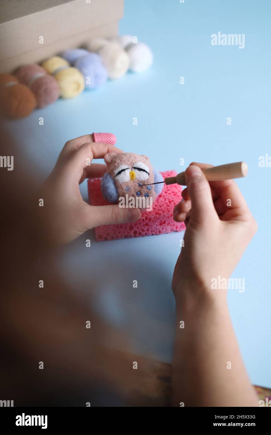 Female hands to create a toy by felting wool. Process of dry felting ...