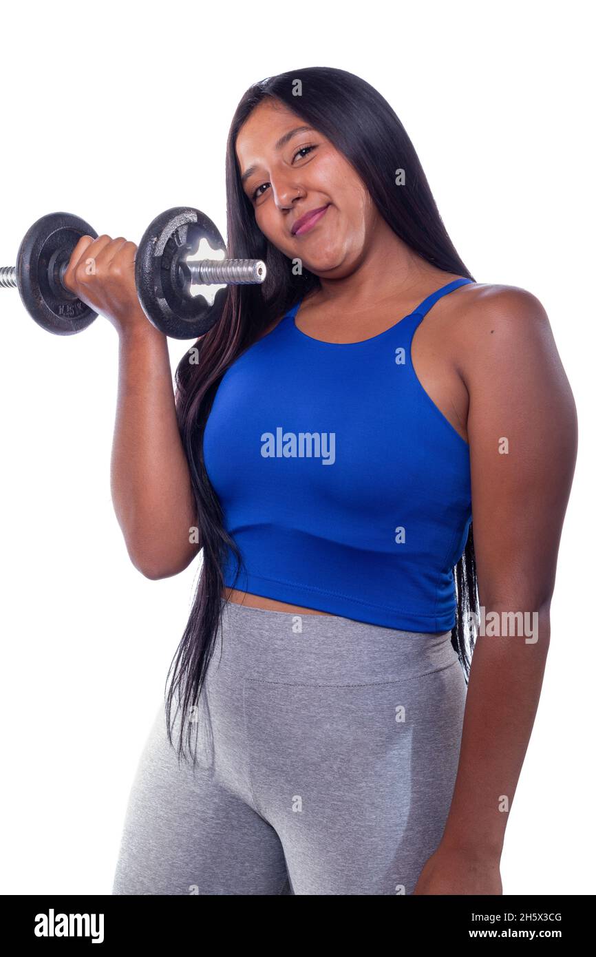 Dark skinned girl lifting a weight from the gym and looking at the ...