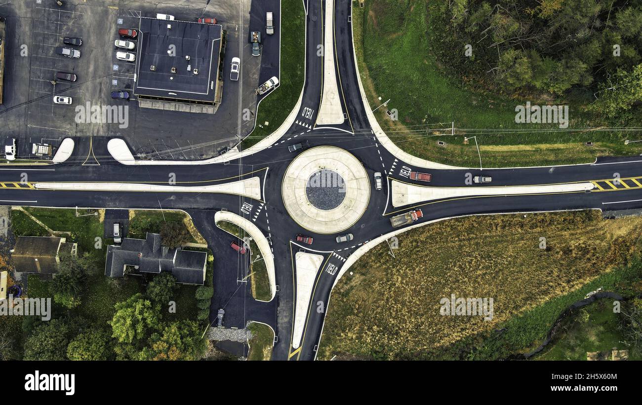 Aerial shot of a roundabout surrounded by greenery in the daylight ...