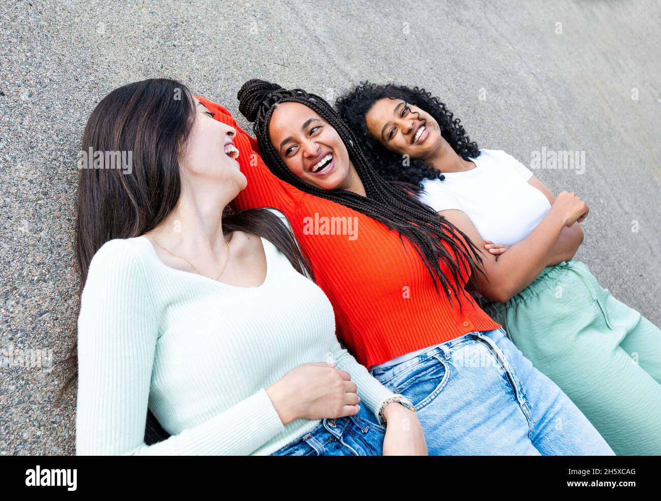 From above of cheerful multiracial girlfriends in trendy outfits ...