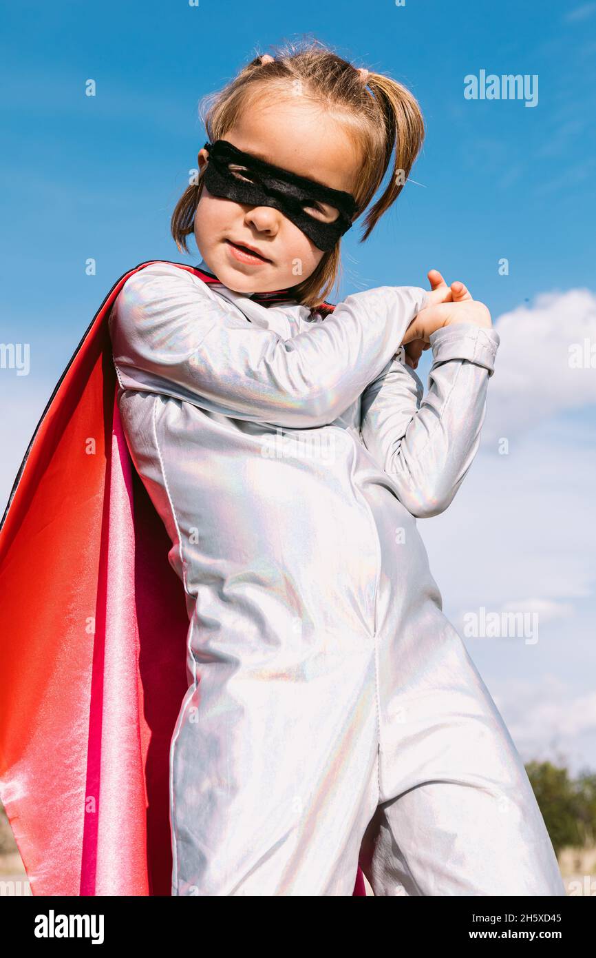 From below cute kid wearing masquerade superhero costume and eye mask ...