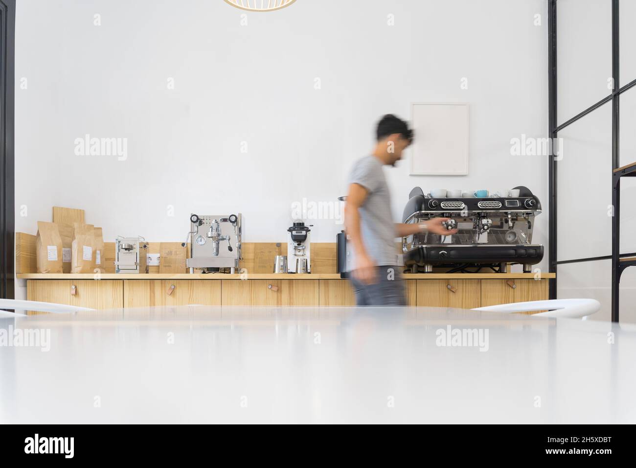 Side view of faceless male barista standing near modern coffeemaker ...