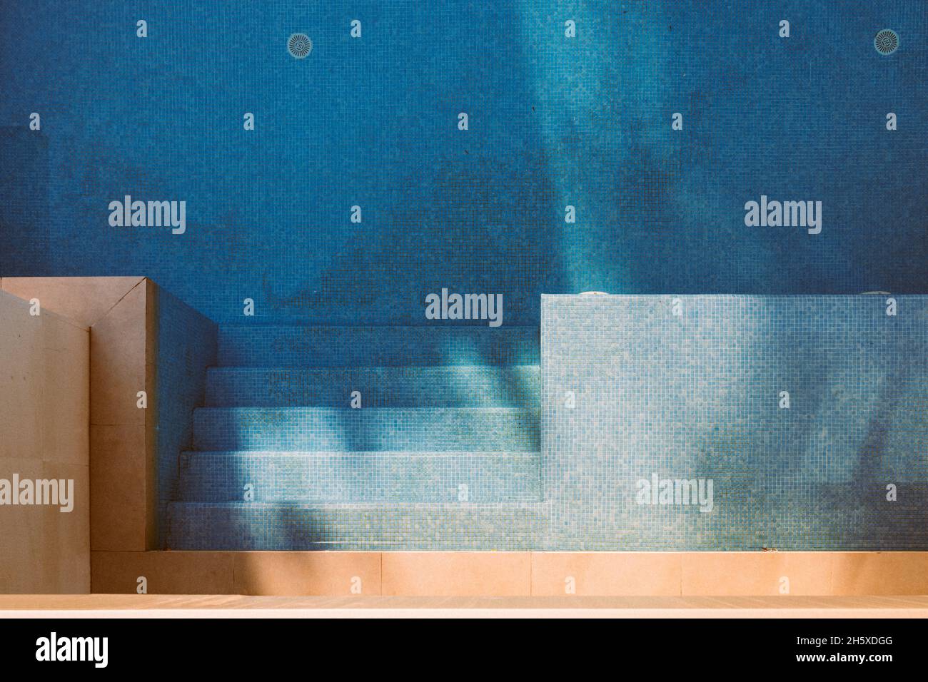 Top view of tiled bottom and steps in swimming pool with clean blue ...