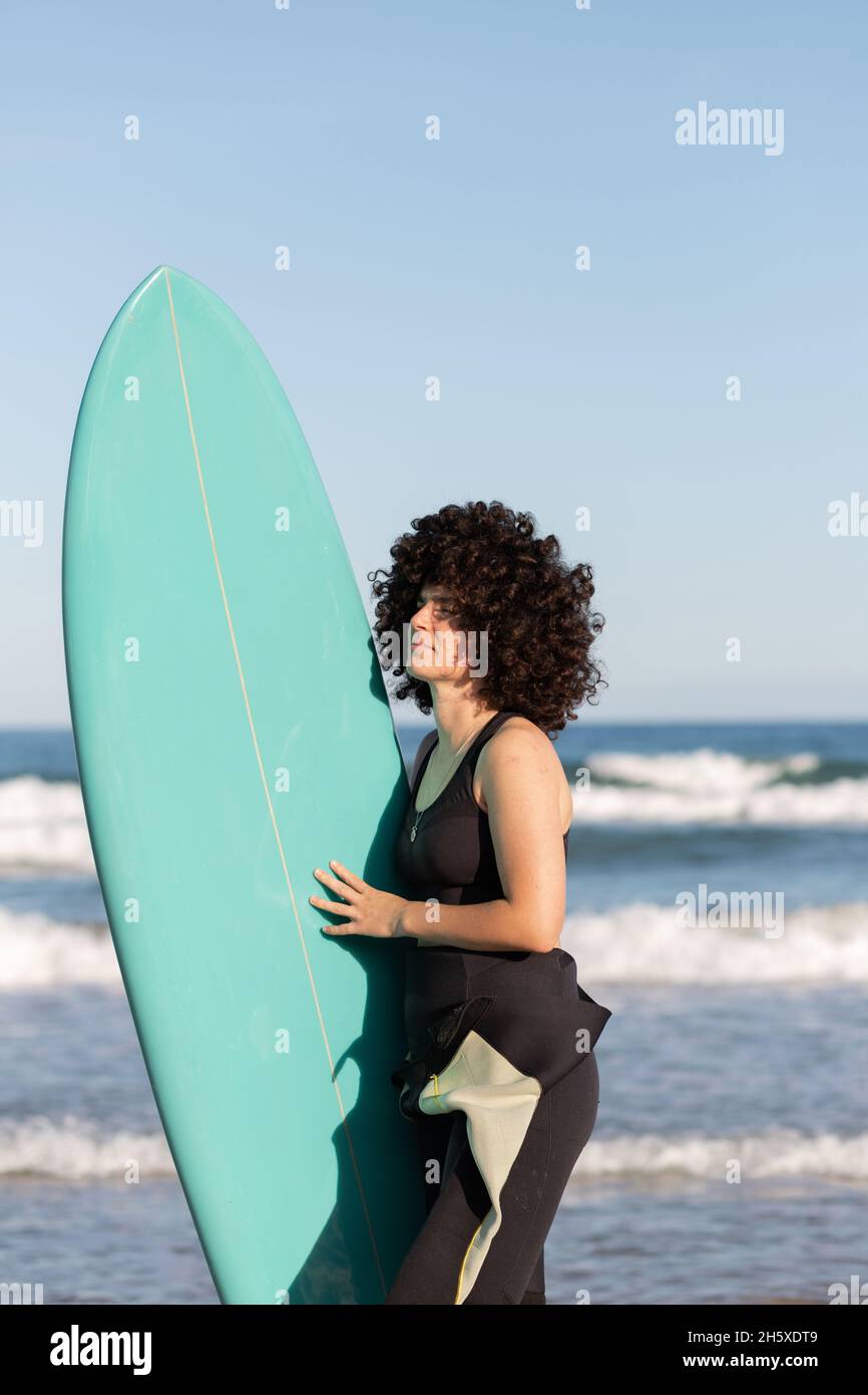 Carefree young African American female with TWS earbuds listening to ...