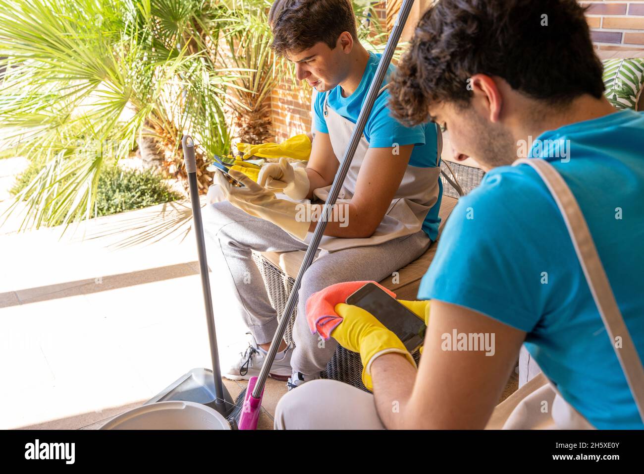 Full body of young male professional cleaning workers in uniform and ...