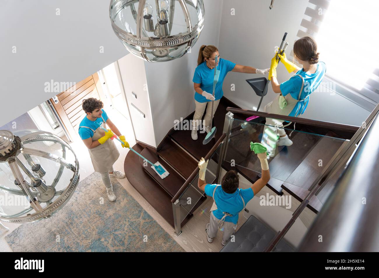 From above of professional female and male housekeepers in uniforms and ...