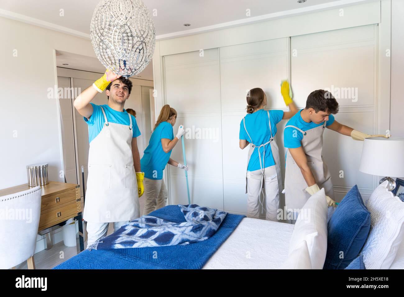 Positive young professional doctor cleaning staff in uniforms and ...