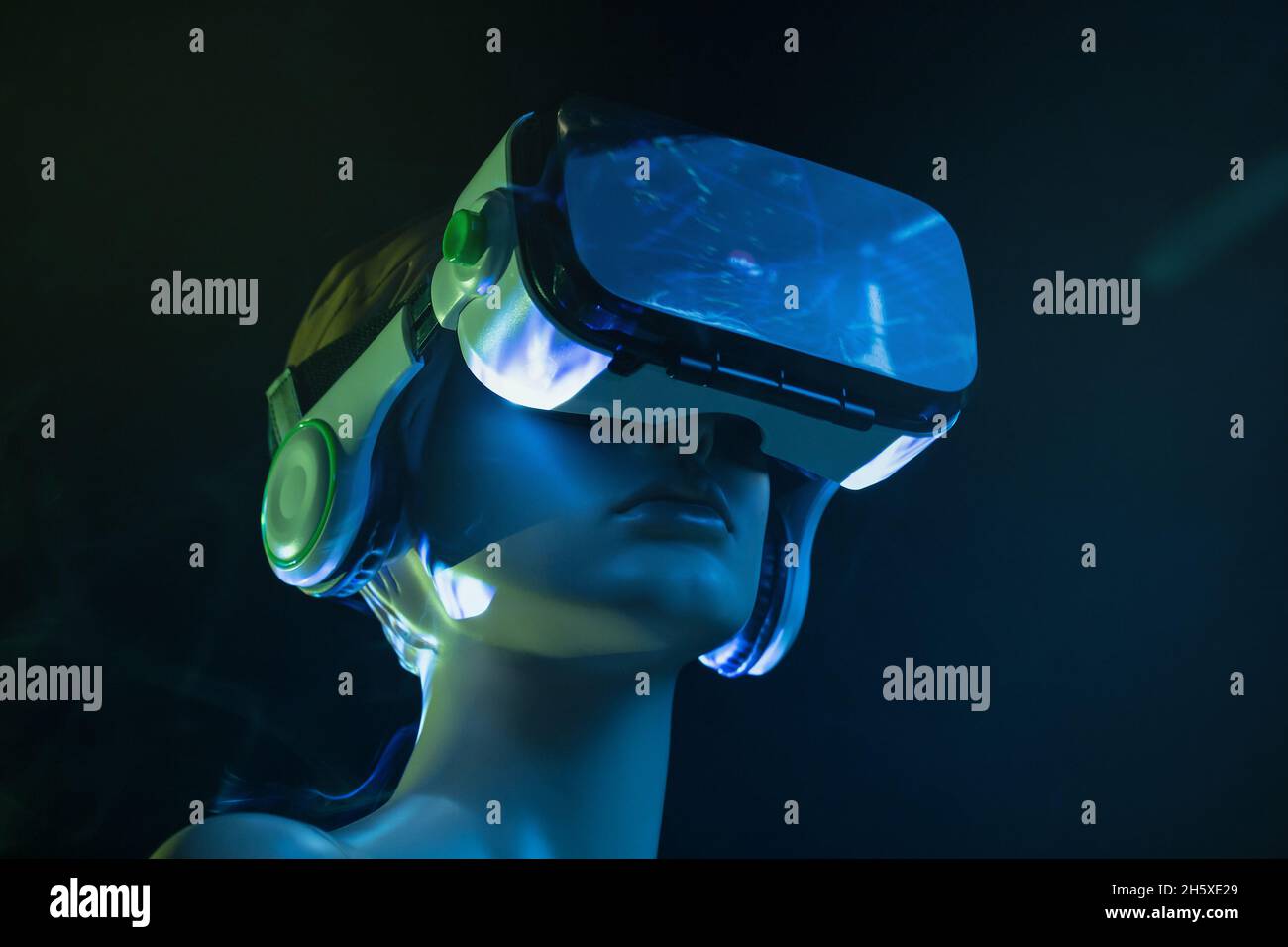 Dummy of Woman in futuristic VR goggles placed under bright projection ...