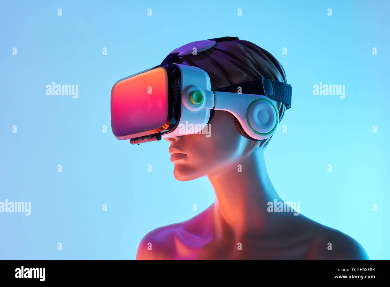 Female dummy with VR goggles placed against bright blue background as ...