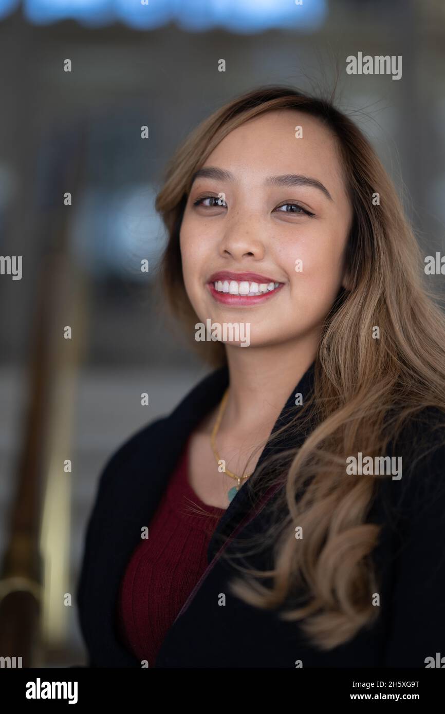 Closeup portrait of a young smiling Filipina woman in fall wardrobe ...