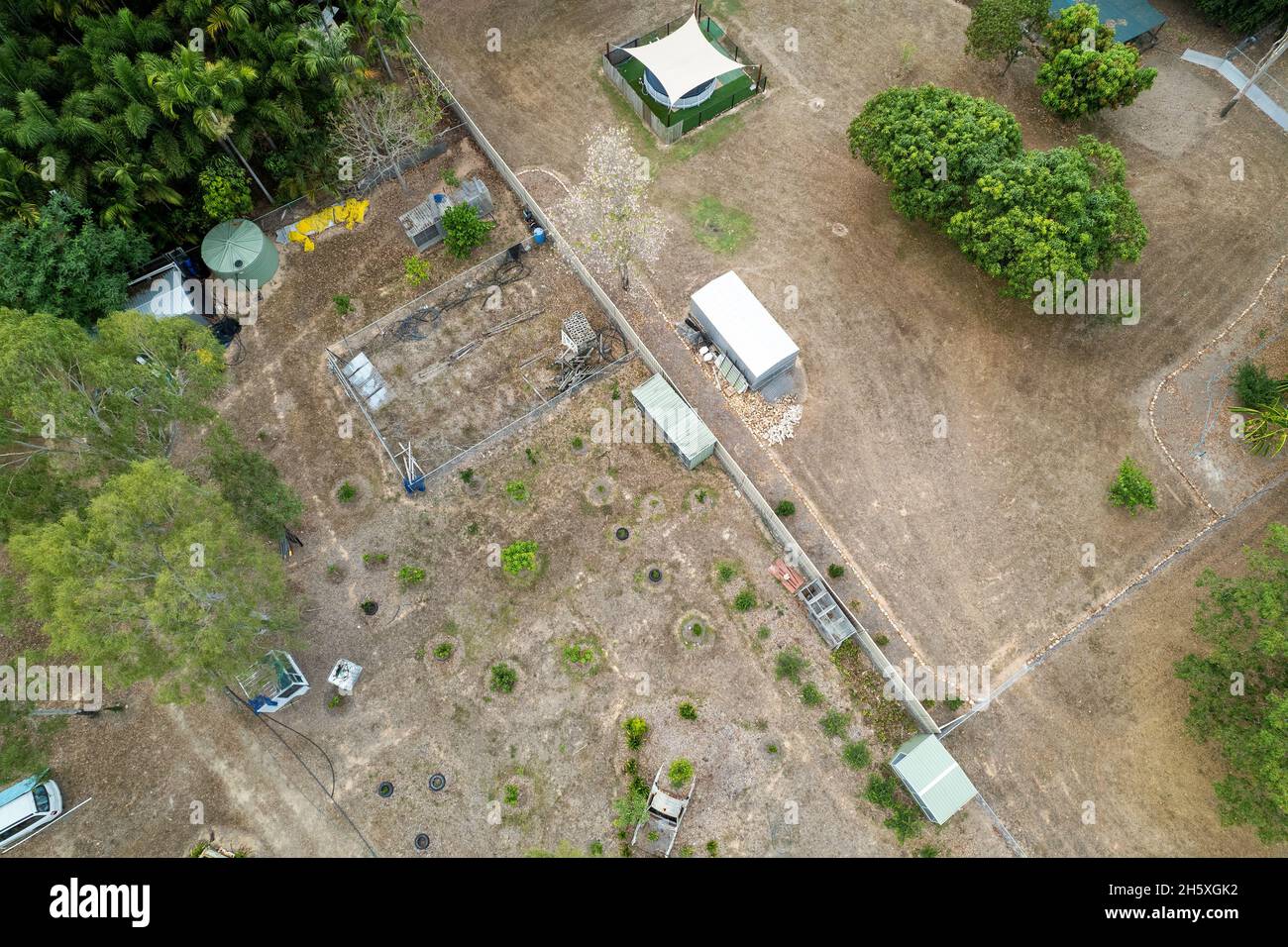 Top down view of rural acreages with fences, pool, cars and trees Stock ...