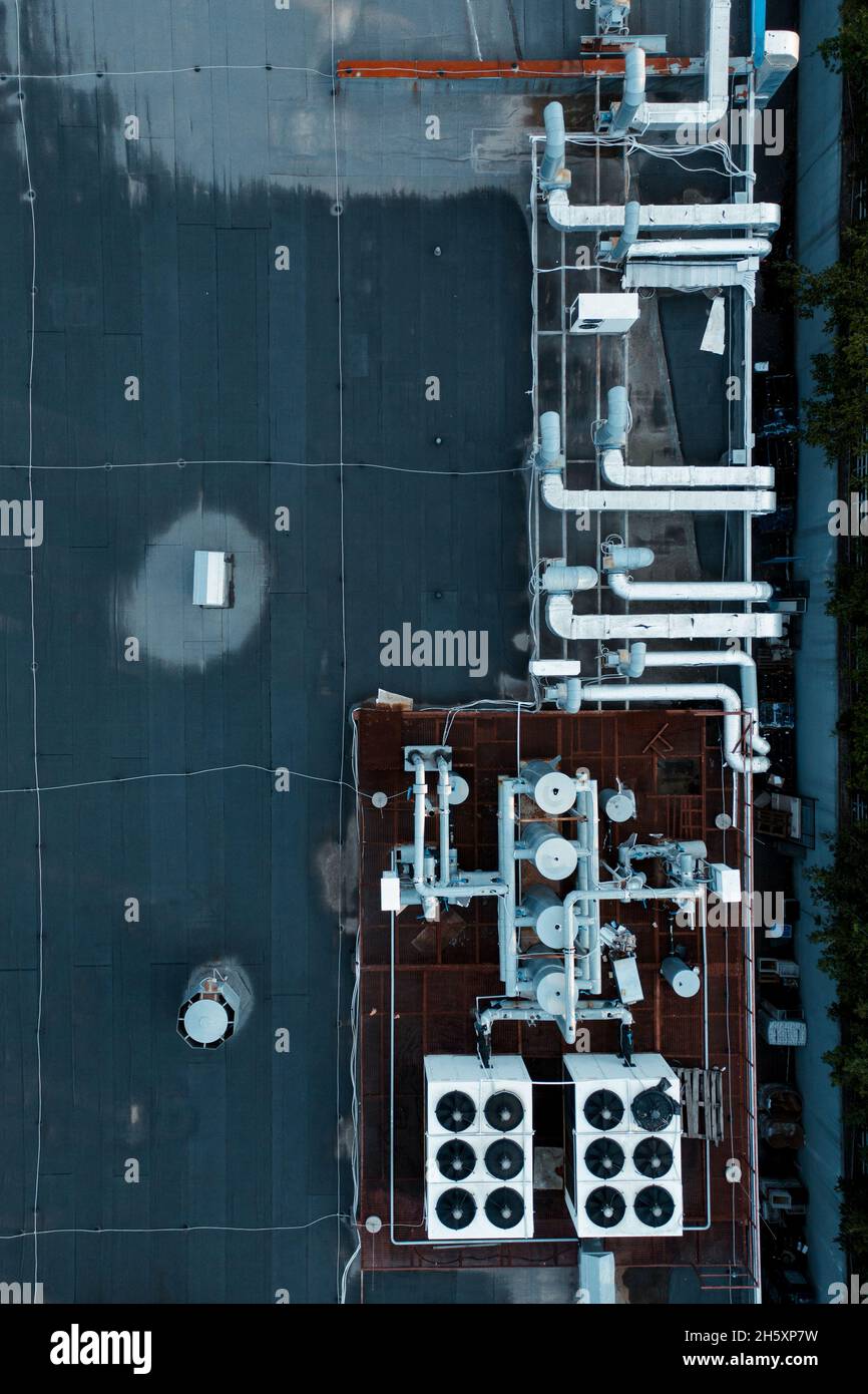 Aerial top view shot. Metal pipes and coolers with fans on the roof of ...