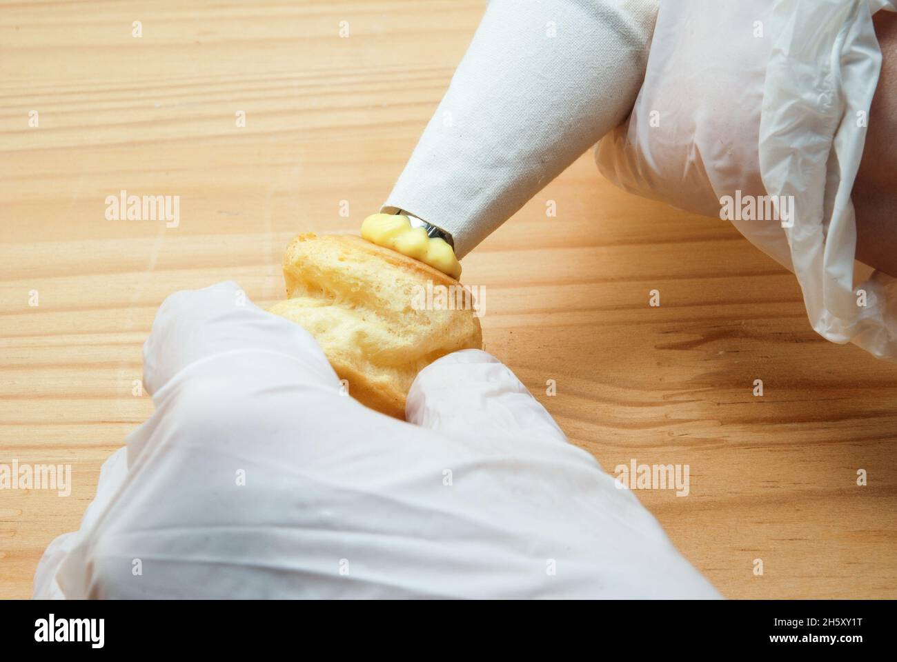 Process of filling an eclair with vanilla custard cream Stock Photo - Alamy