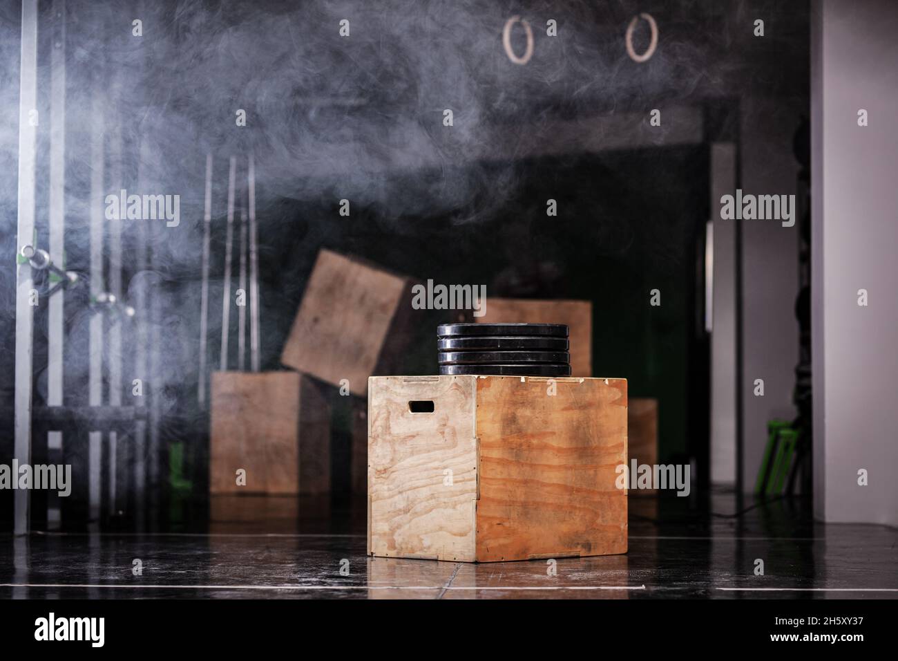 Workout interior with wooden boxes and smoke. Generic fitness studio ...