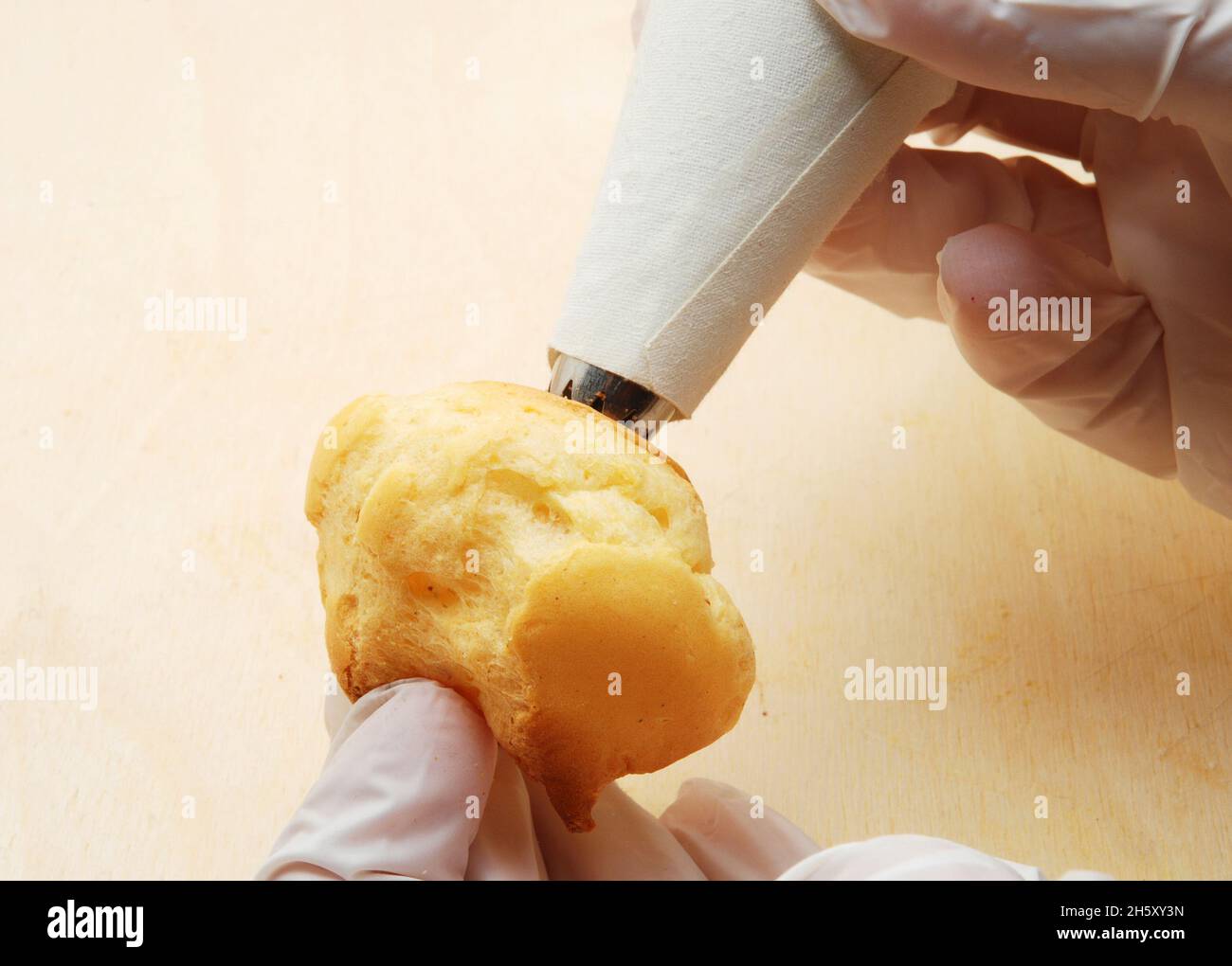 Process of filling an eclair with vanilla custard cream Stock Photo - Alamy