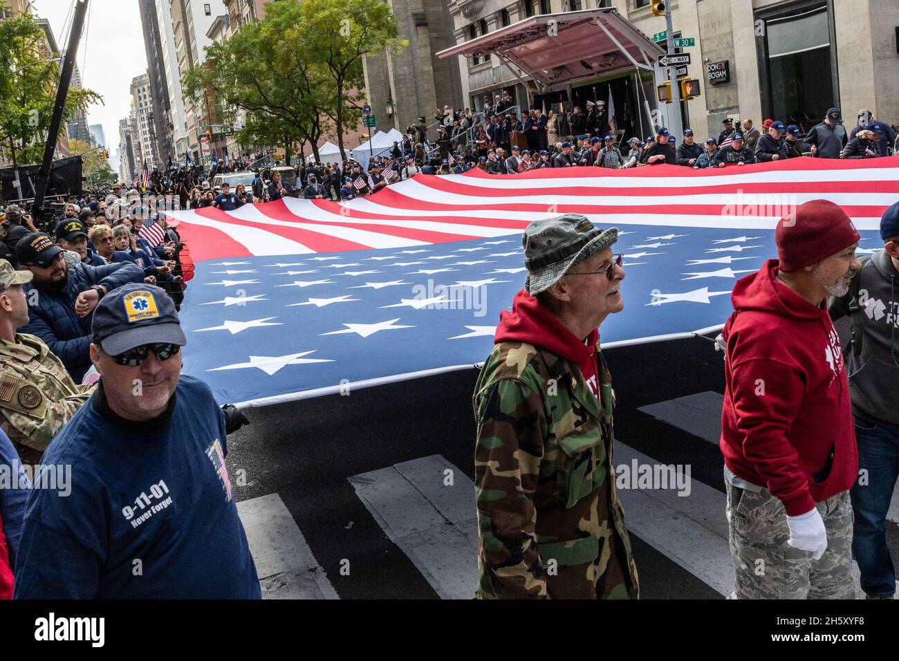 Parade marchers carry a large US flag during the 102nd Annual New York ...