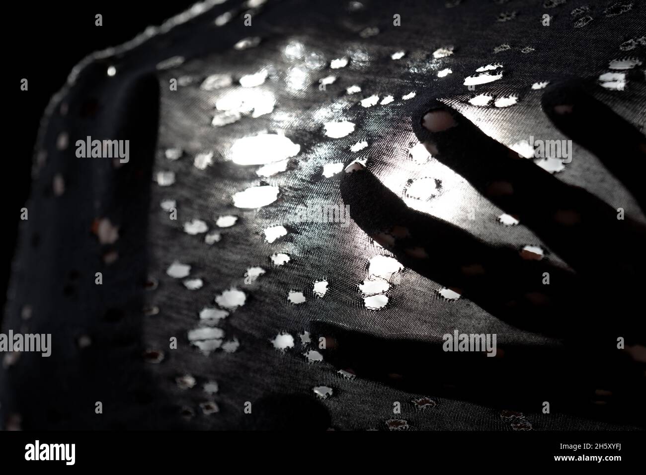 Abstract silhouette hands streching and pushing half transparent fabric ...