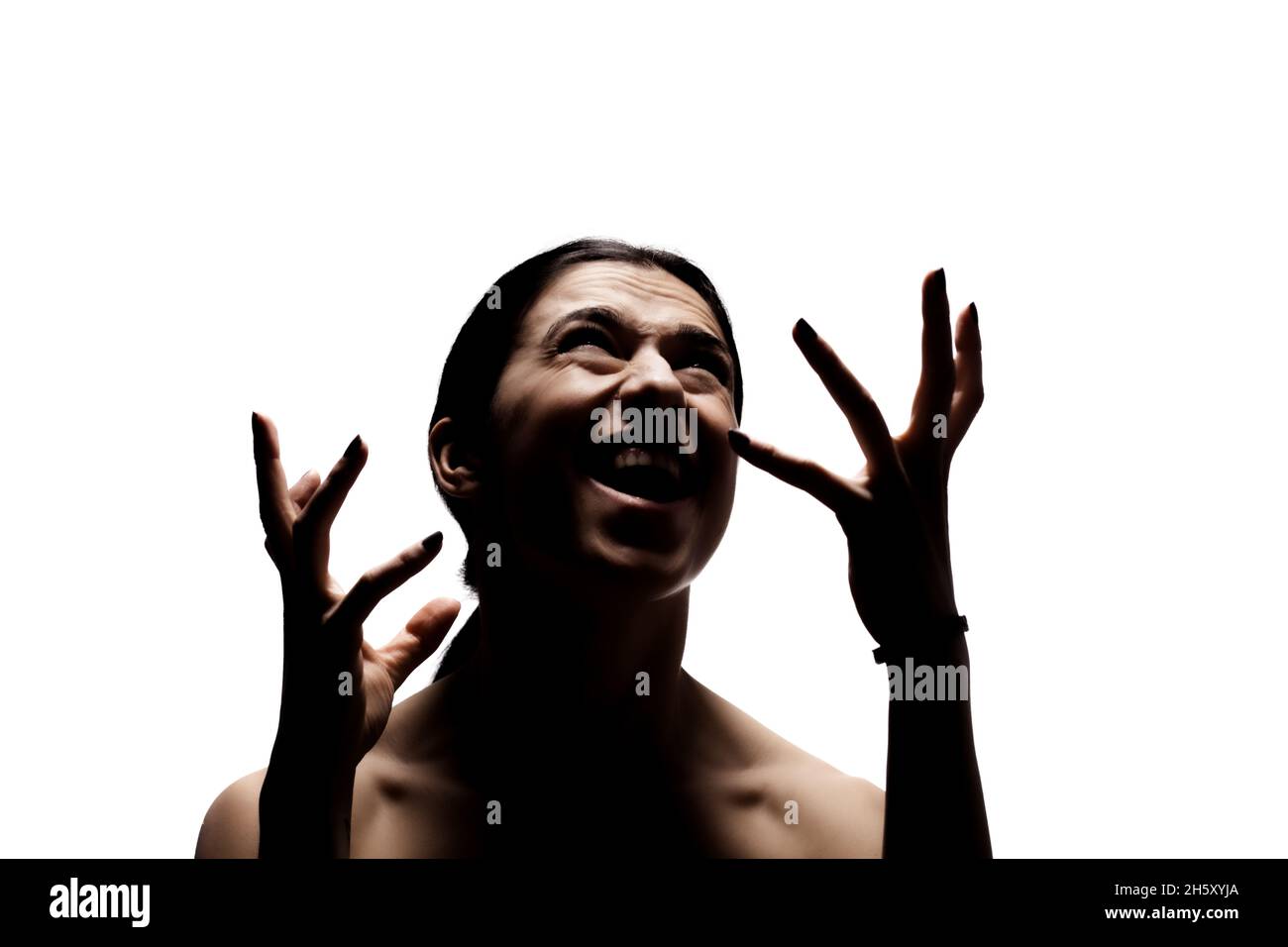 Dark half silhouette portrait with shadows of an angry girl looking up ...