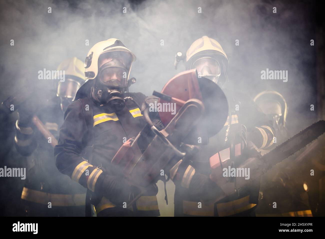 Group of professional firefighters wearing full equipment, oxygen masks ...