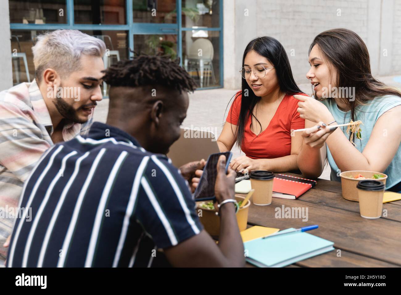 Diverse friends having fun eating take away food outdoor - Multiracial ...