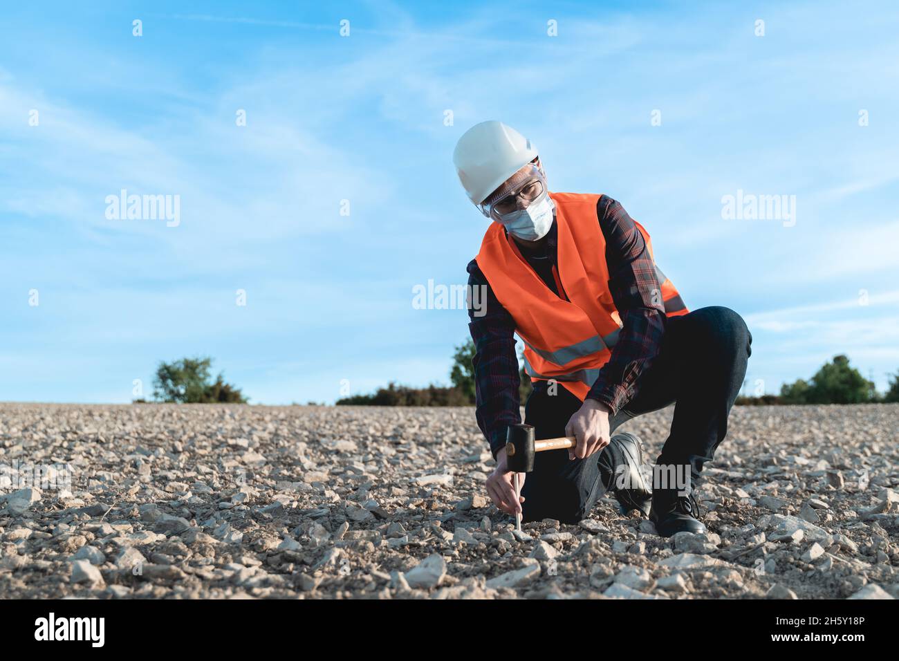 Engineer man doing topographic measures on land for construction work ...