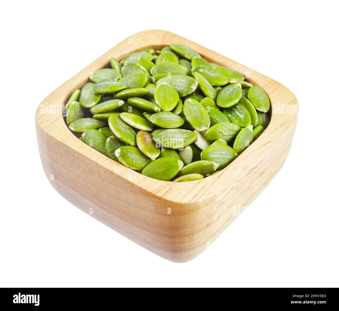 Pumpkin seeds green peeled in wooden bowl isolated on white background ...