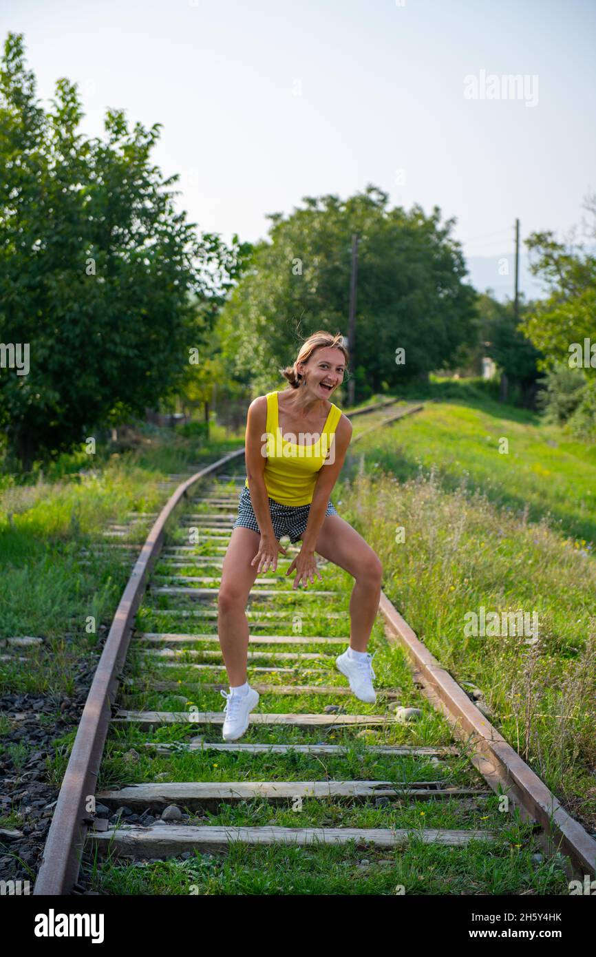 cheerful girl jumping on the railroad tracks Stock Photo - Alamy