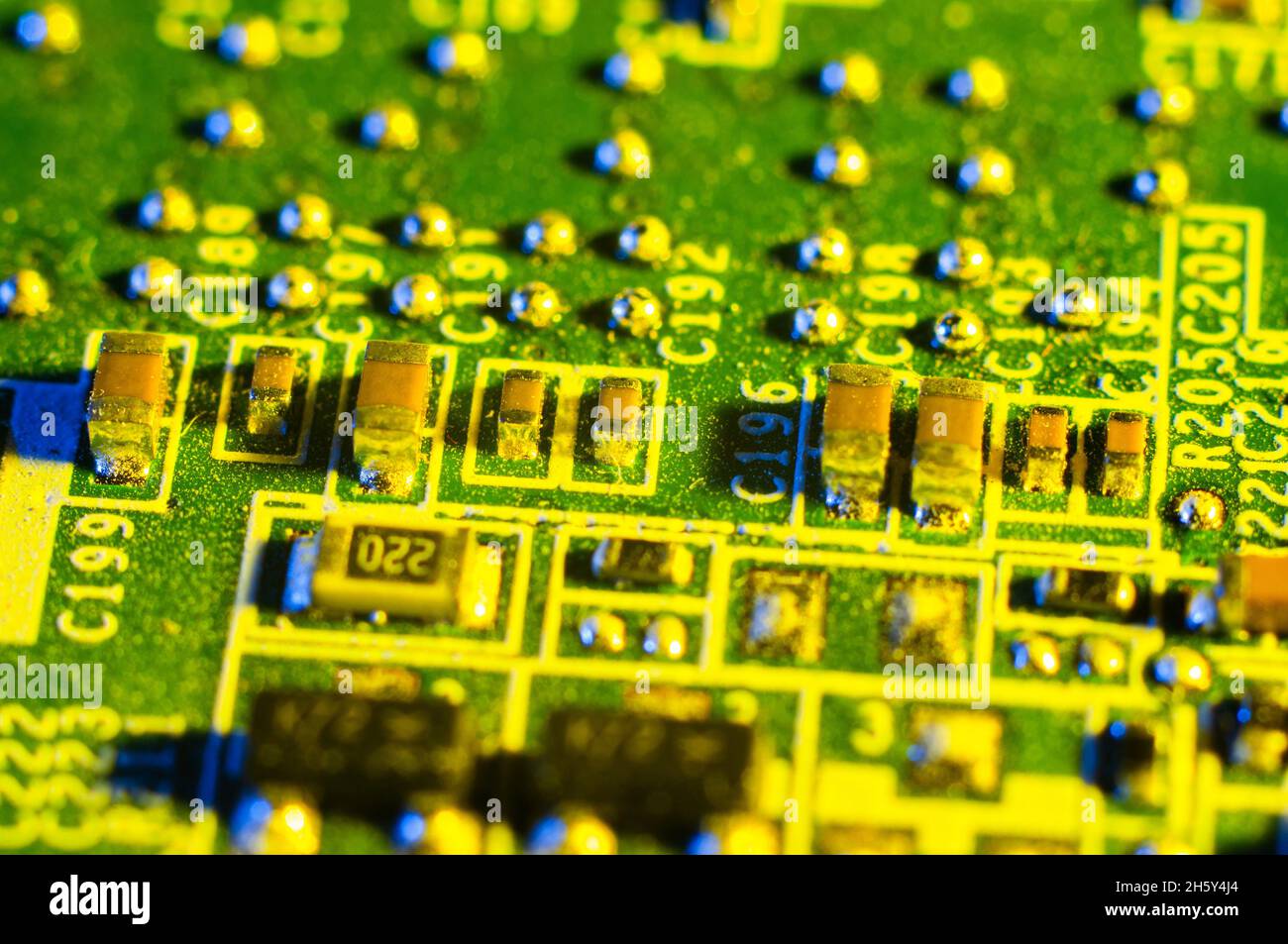 Old electronic circuit board close up in macro photography, yellow ...