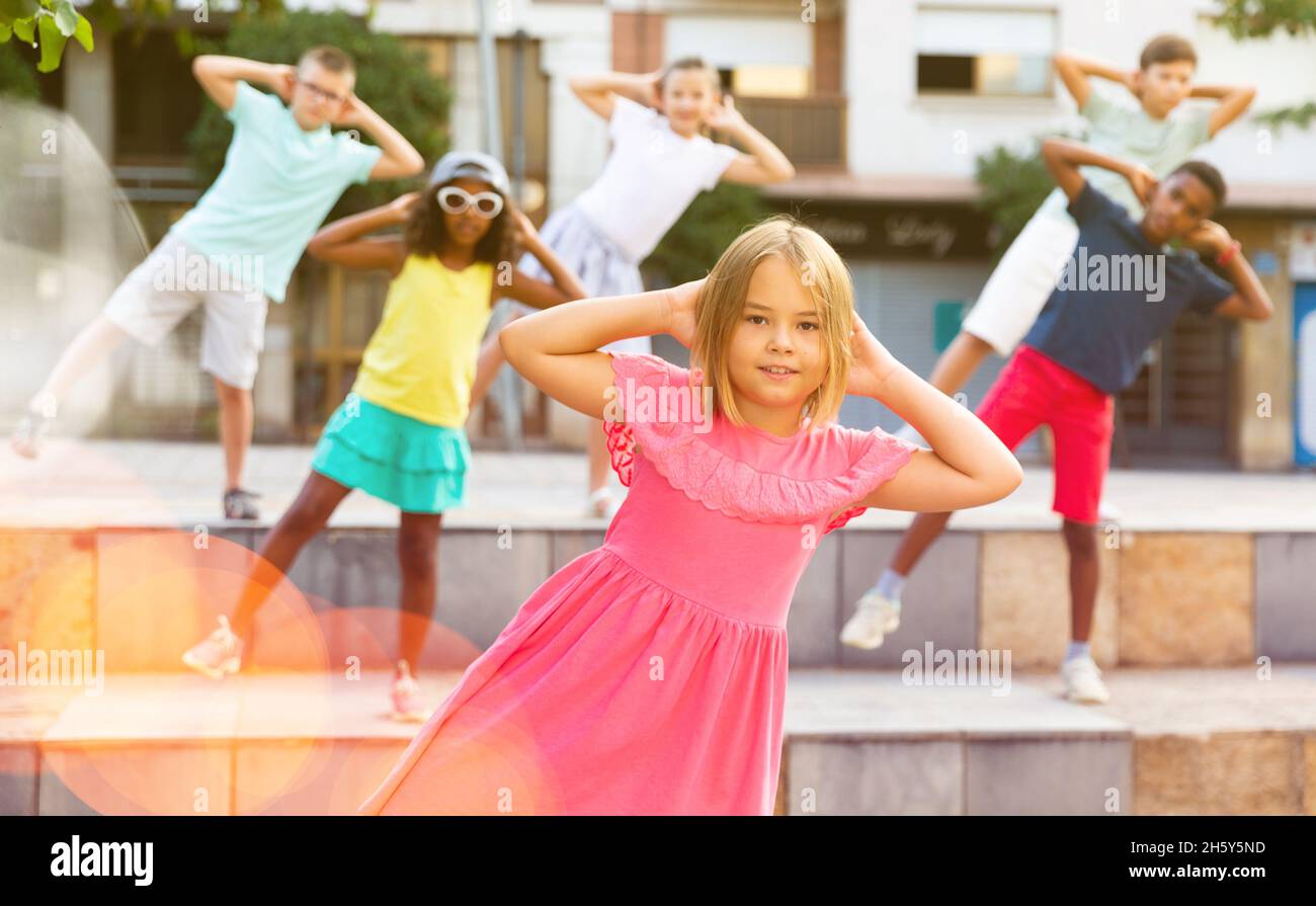 Smiling tween girl street dancer posing during performance with group ...