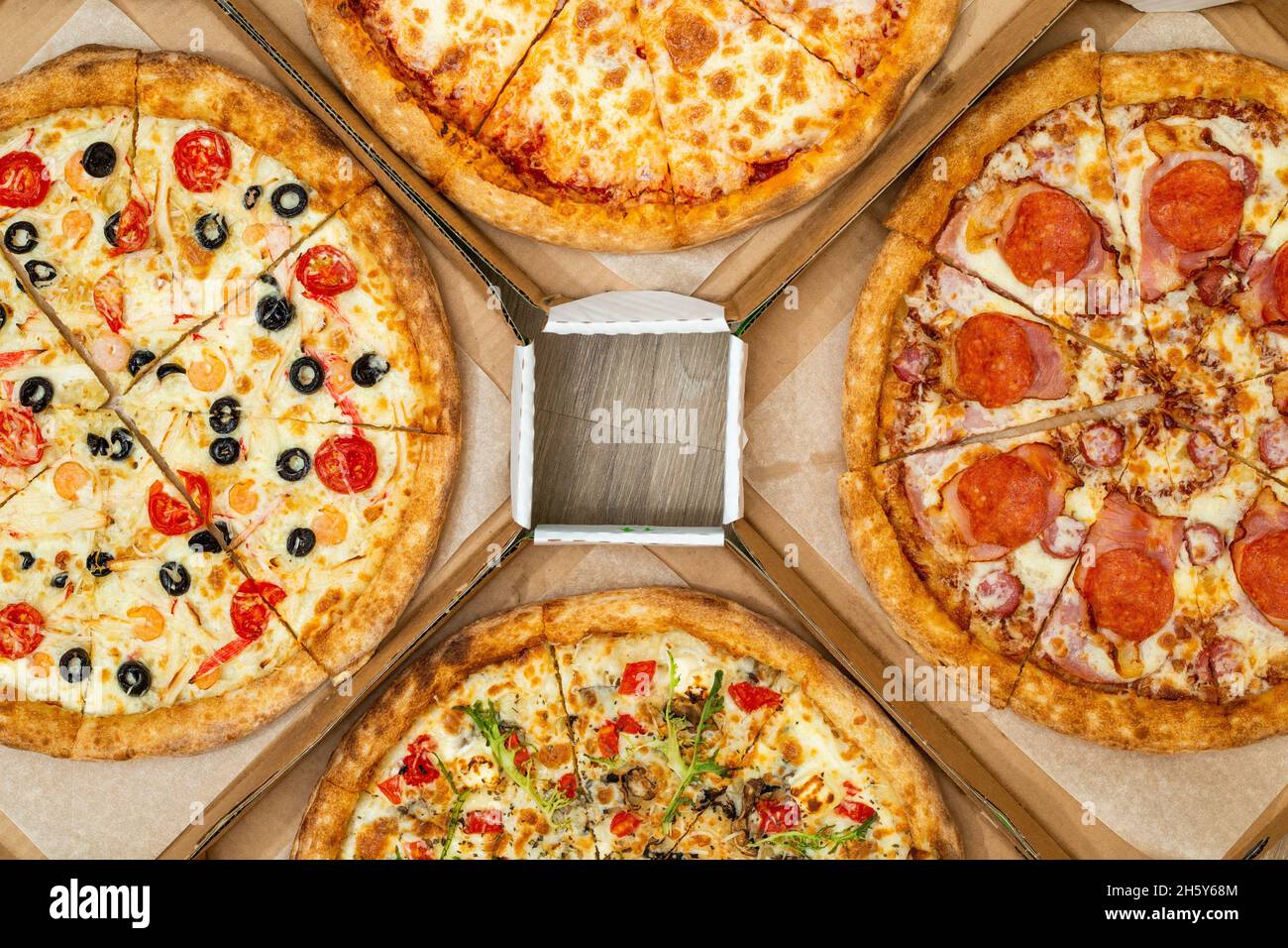 Four different cut pizzas are in square boxes. Meat and vegetarian ...