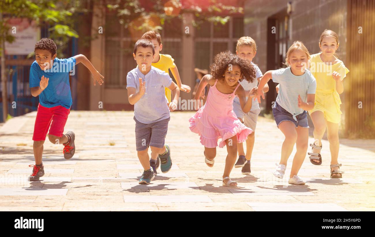 Team of positive kids running in race in the street and laughing Stock ...