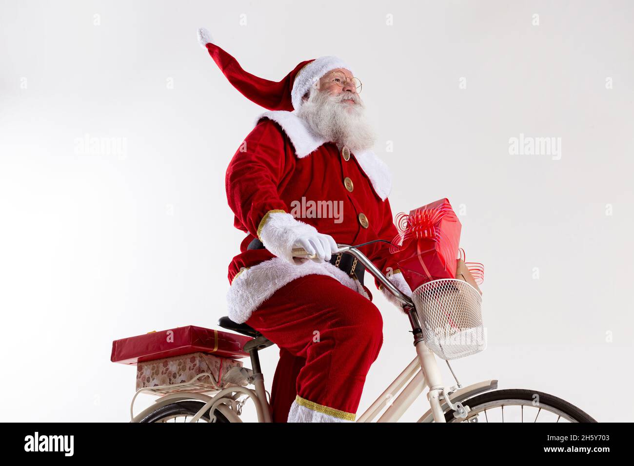 Santa Claus on bicycle delivering Christmas gifts Stock Photo - Alamy