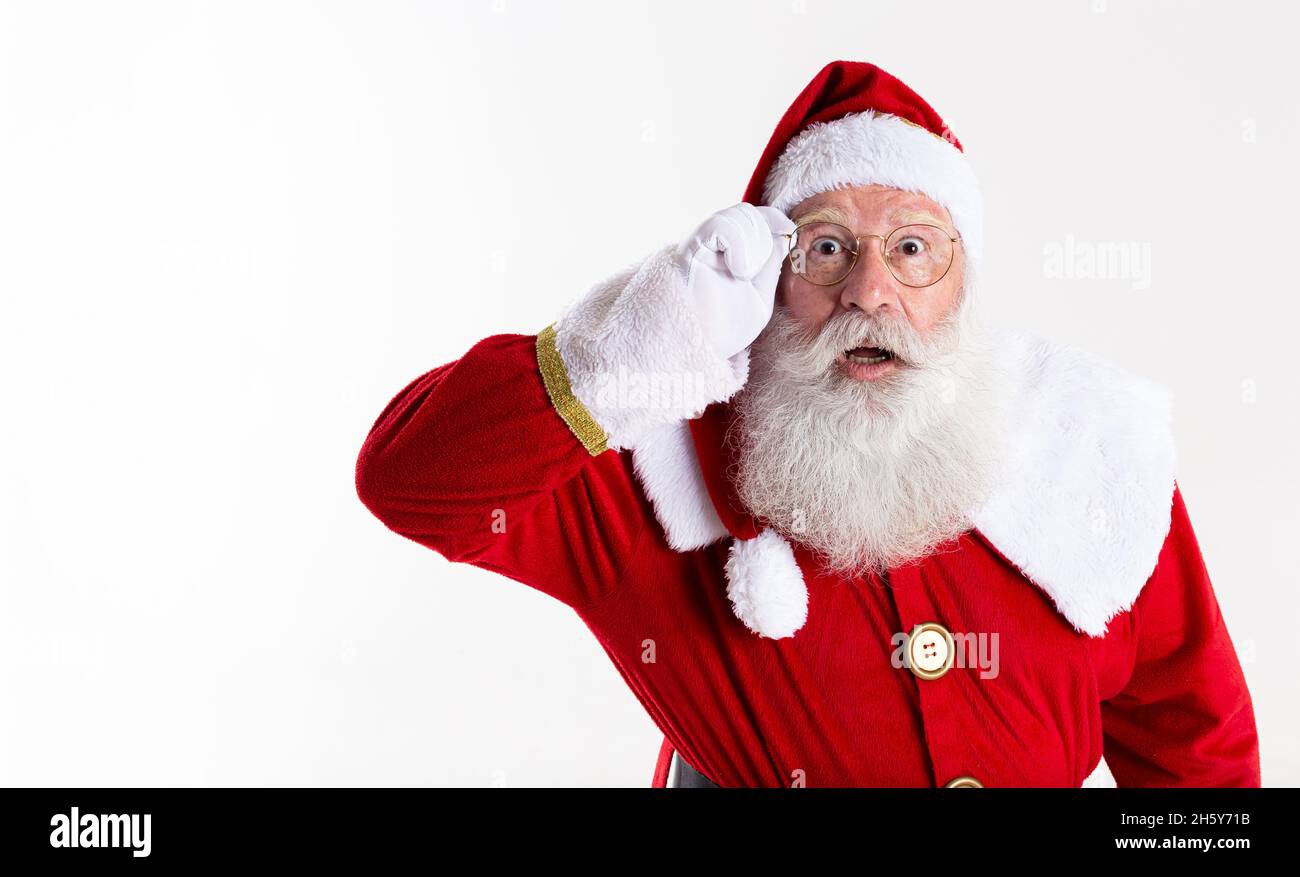 Santa Claus in eyeglasses is looking surprised at camera on white ...