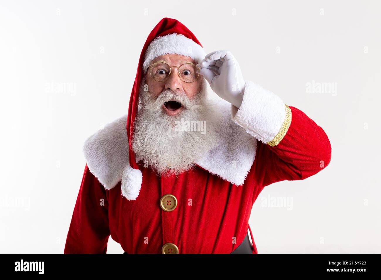 Santa Claus in eyeglasses is looking surprised at camera on white ...