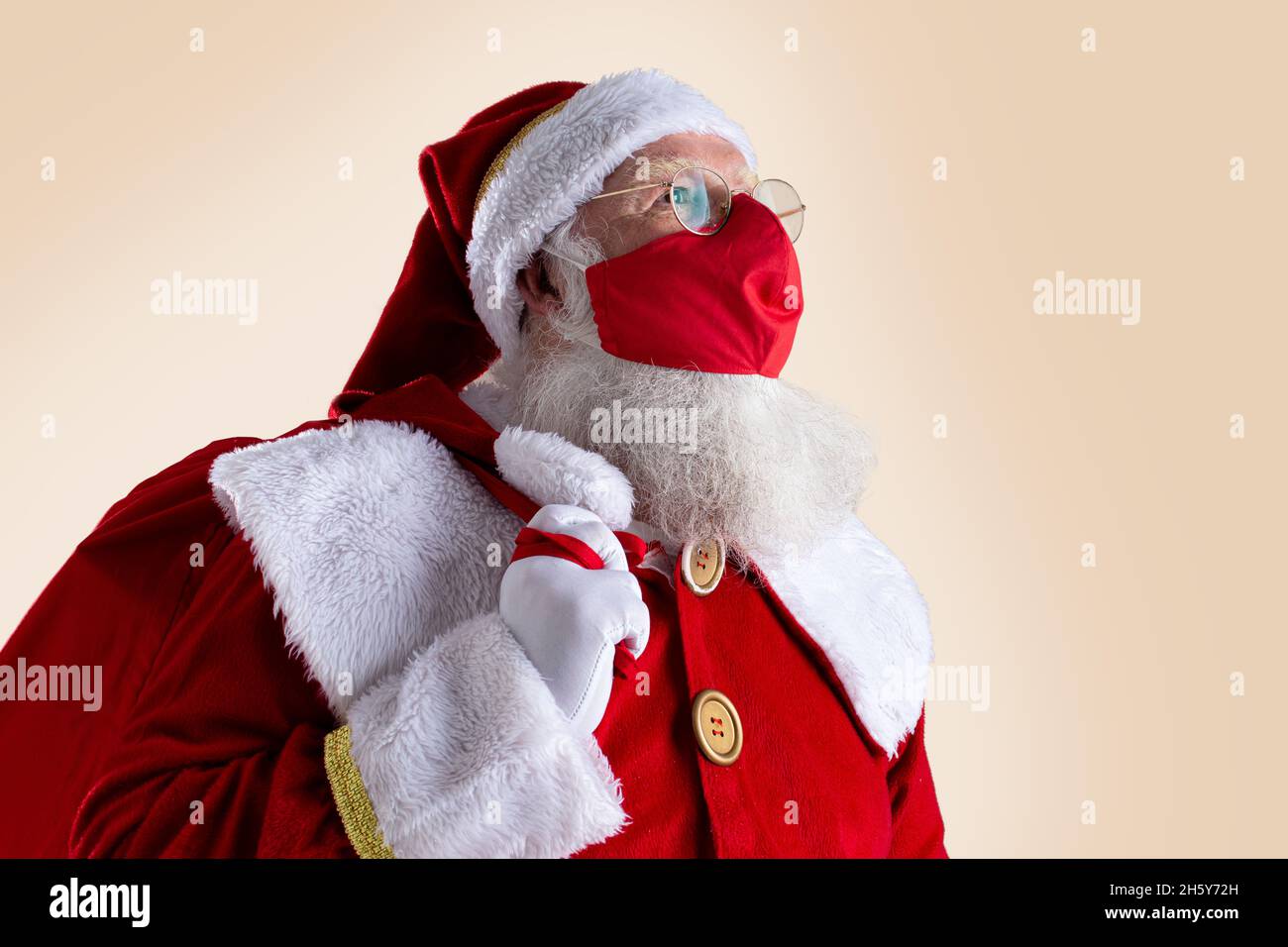 Santa Claus smiles behind red Covid-19 safety face mask. Christmas with ...