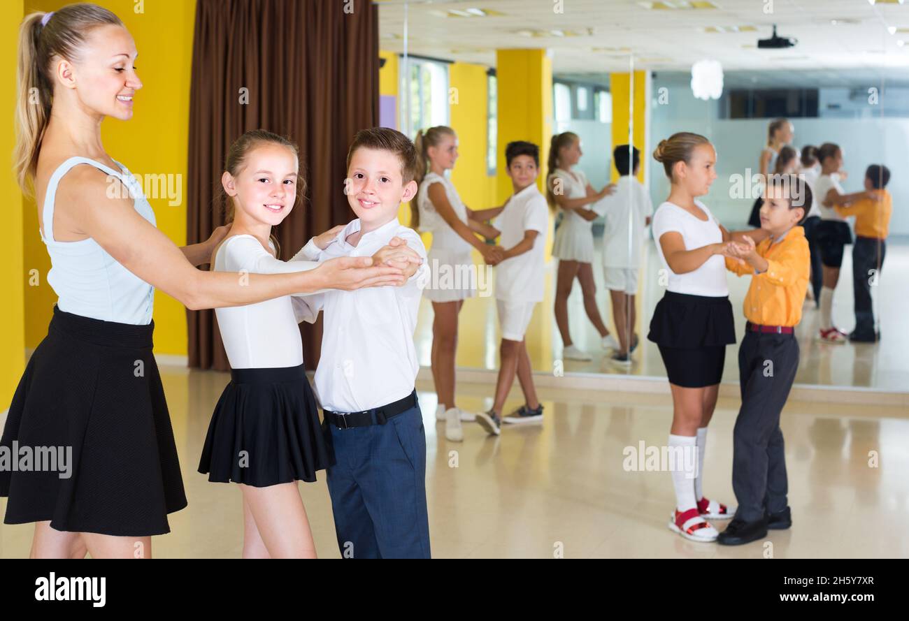 Teacher is demonstrating to children how to dance tango Stock Photo - Alamy