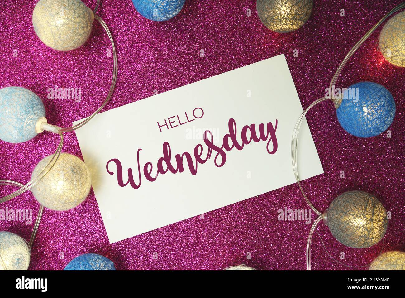 Hello Wednesday typography text with LED cotton ball on pink glitter ...
