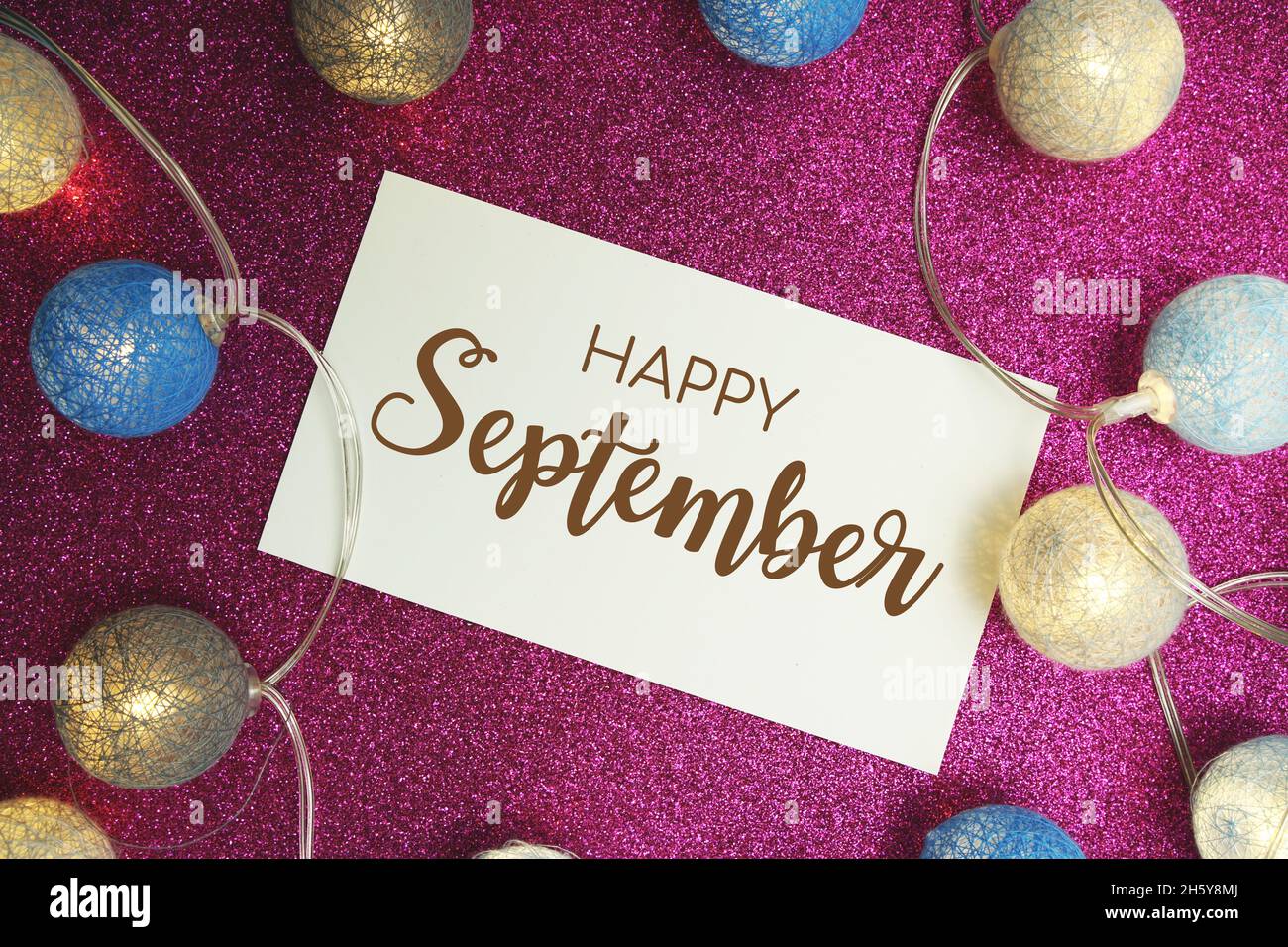 Happy September typography text with LED cotton ball on pink glitter ...
