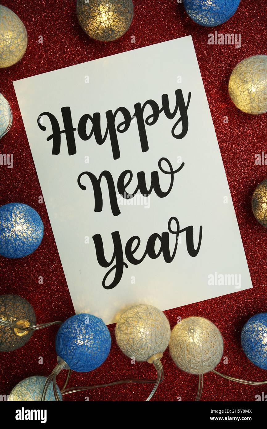 Happy New Year typography text with LED cotton ball on red glitter ...