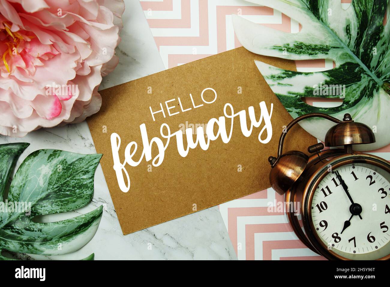 Hello February typography text on paper card with alarm clock and ...
