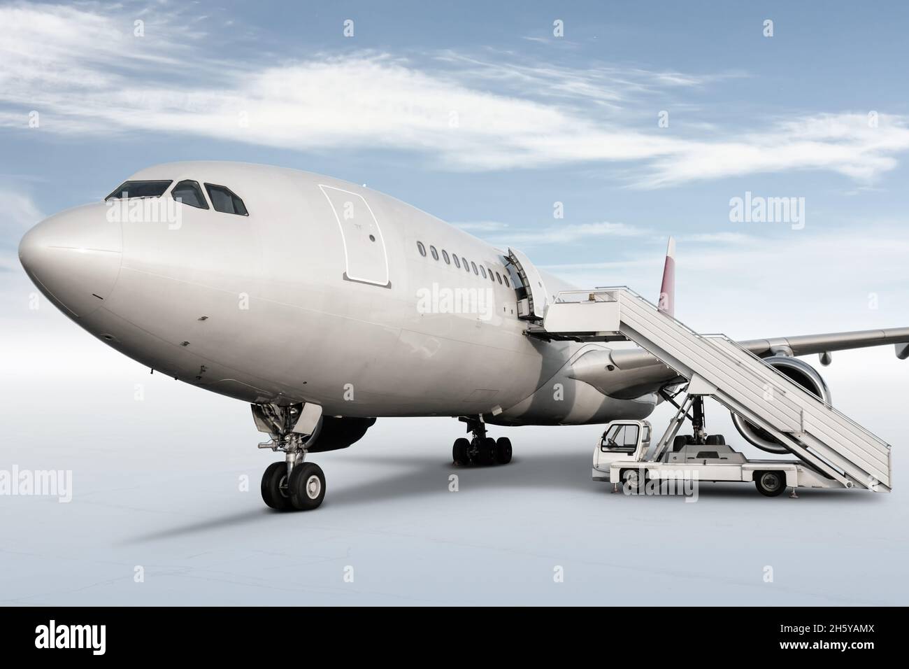 Wide body passenger aircraft with air-stairs at the airport apron ...