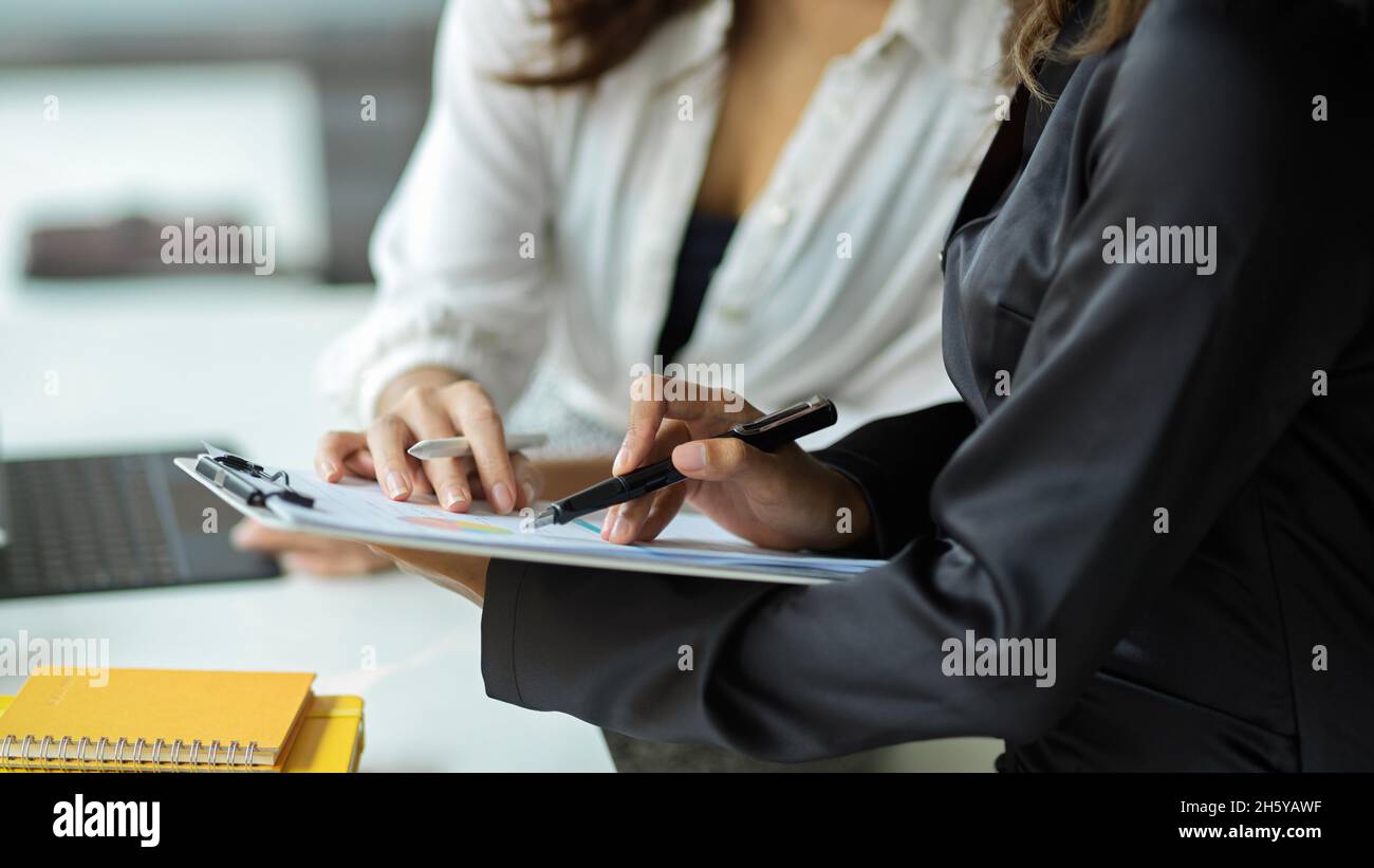 Female boss reviewing and providing feedback on her assistant's work ...