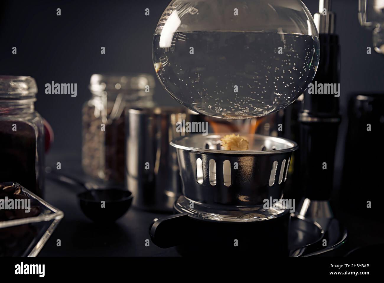 close up of lighter heating vacuum coffee maker also known as vac pot ...