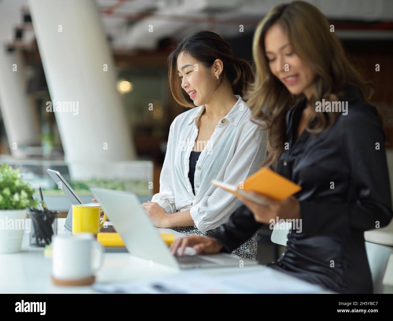 Millennial business employees sitting in modern office, working on ...